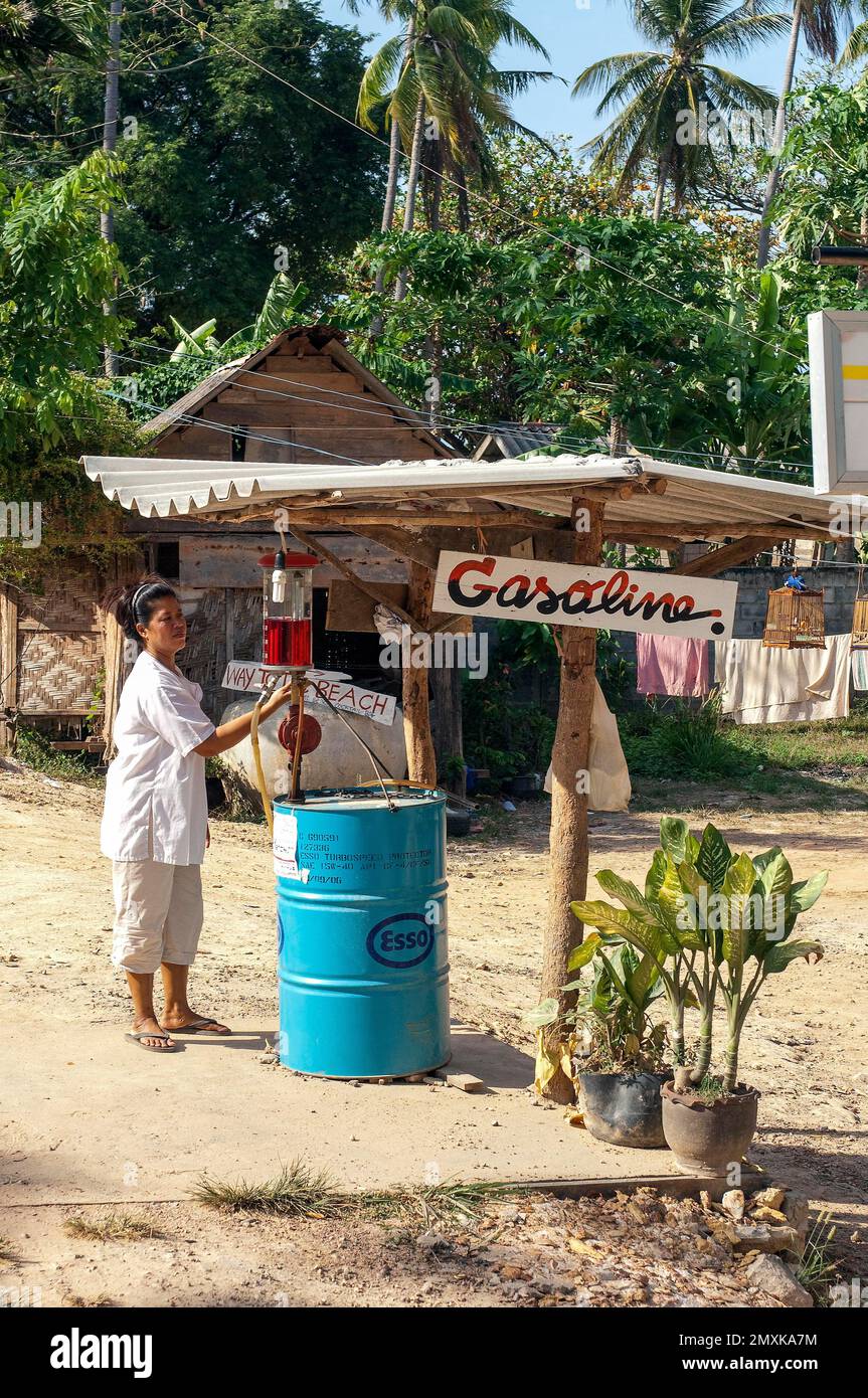 Thai woman operates rural simple petrol station with large gasoline ...