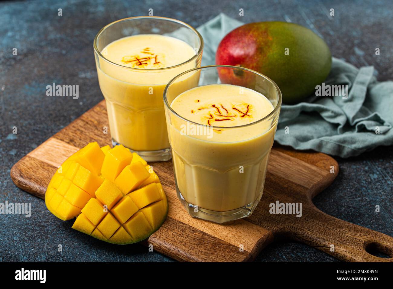 Healthy Indian Ayurveda drink mango lassi in two glasses on rustic ...