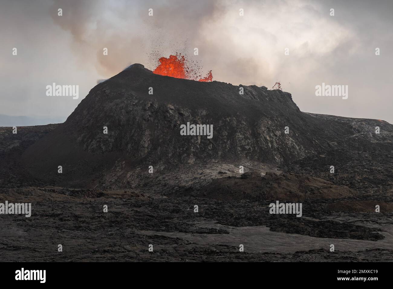 Lava fountain spraying from crater, cooled lava flows, active table ...