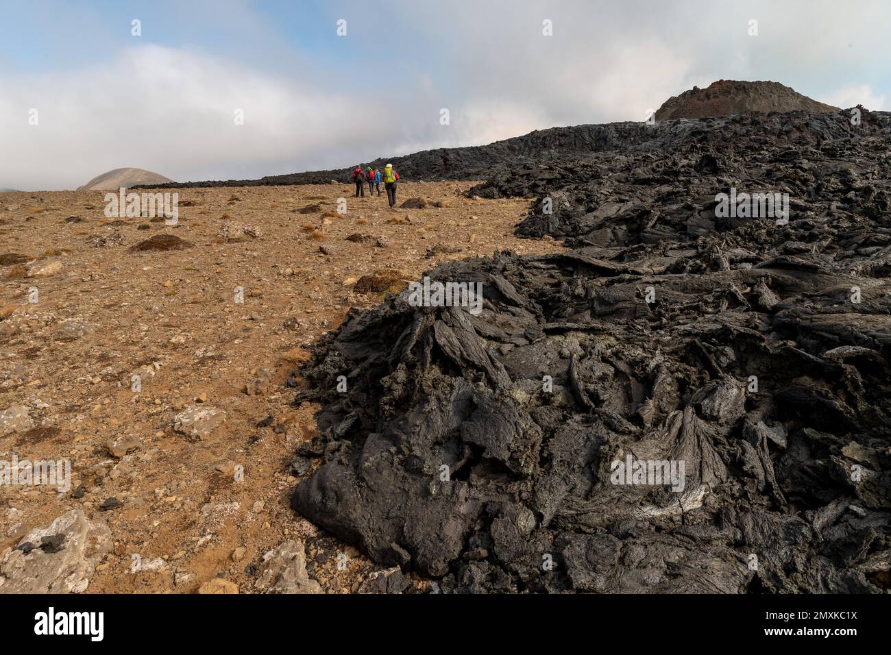 Tourists walk along cooled lava flows, extinct crater, Fagradalsfjall ...