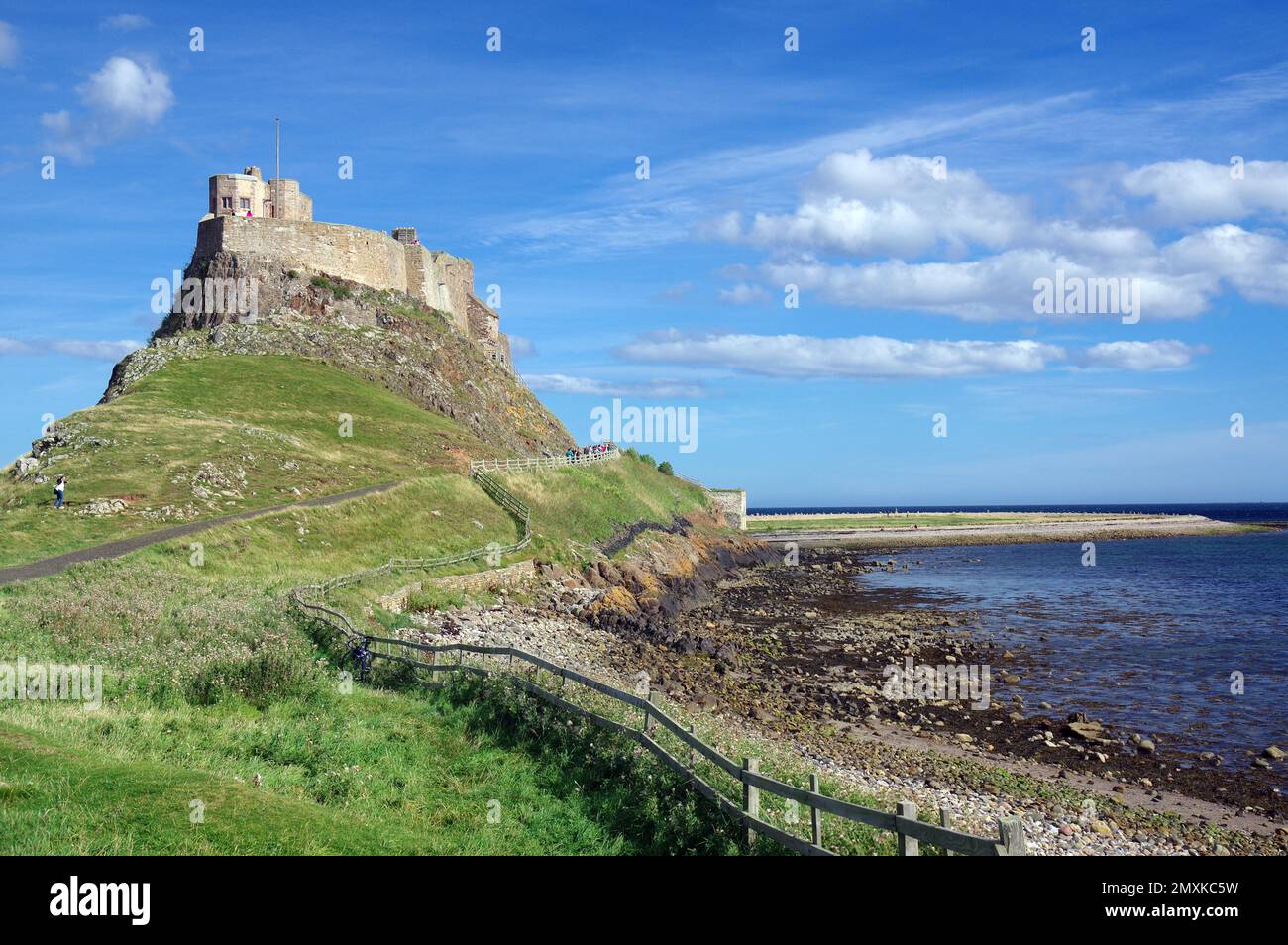 Castle on hill above sea, stony beach, Lindisfarne Castle, Holy Island ...