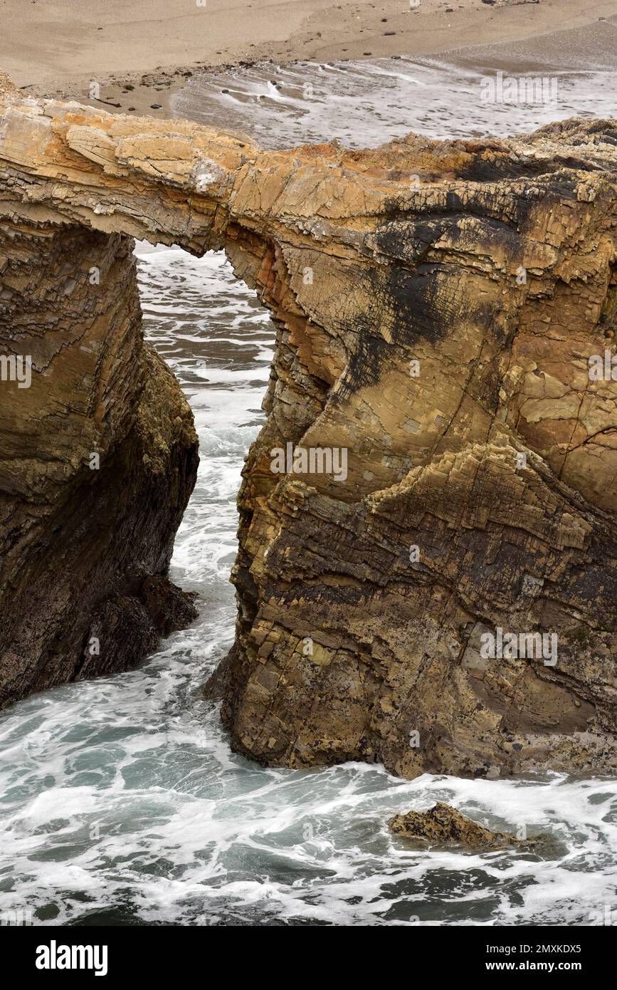 Sandstone arch over Pacific Ocean with waves crashing, Montana de Oro ...
