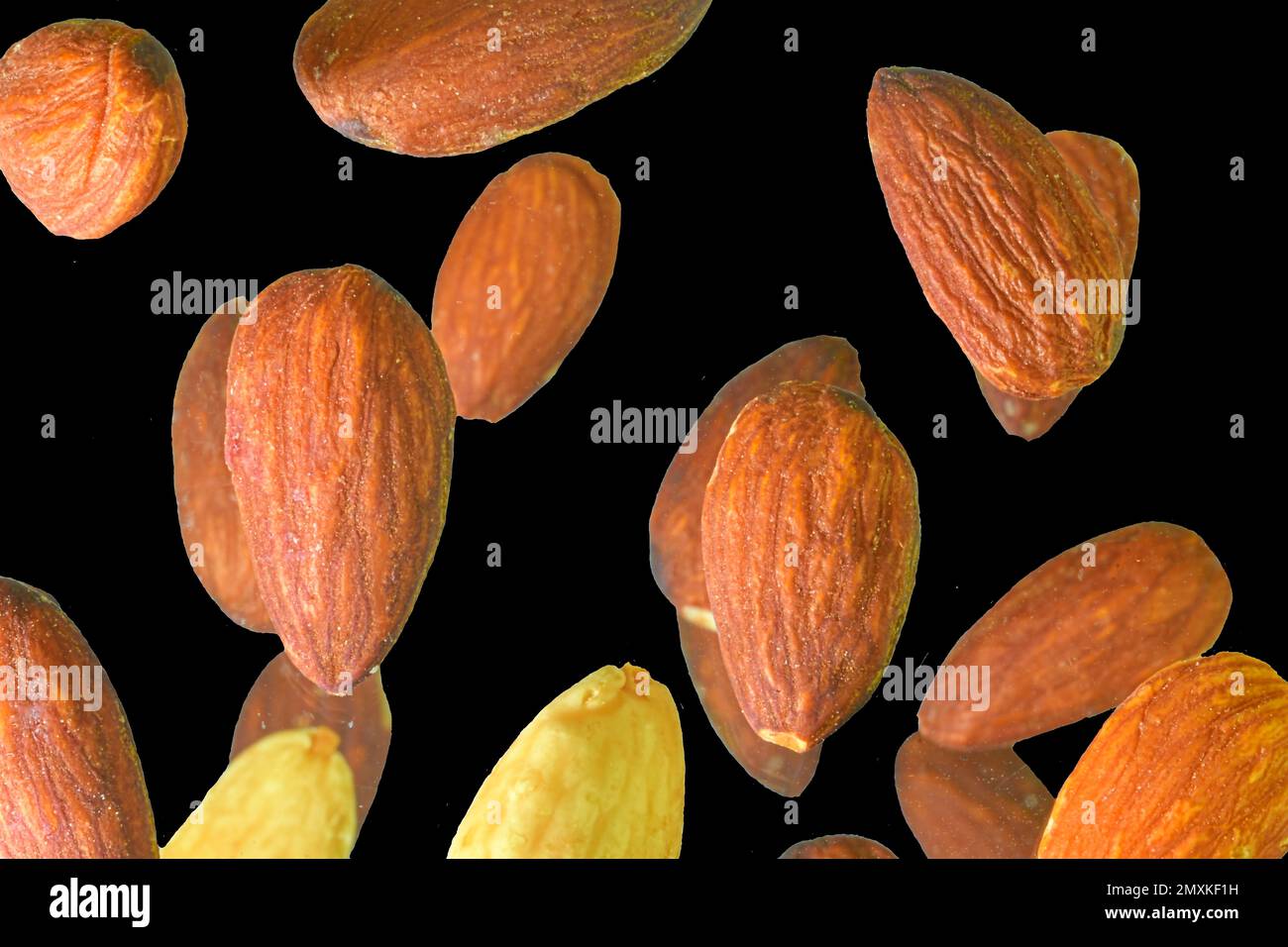 Falling almond isolated on a black background, selective focus. Almond ...