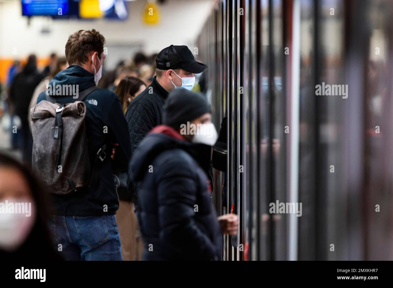 Group of people wearing face masks boarding the S-Bahn at Marienplatz ...
