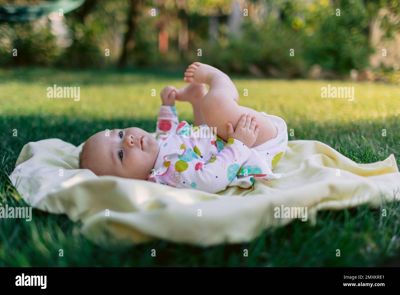 Little baby girl playing in backyard garden on the lawn Stock Photo - Alamy