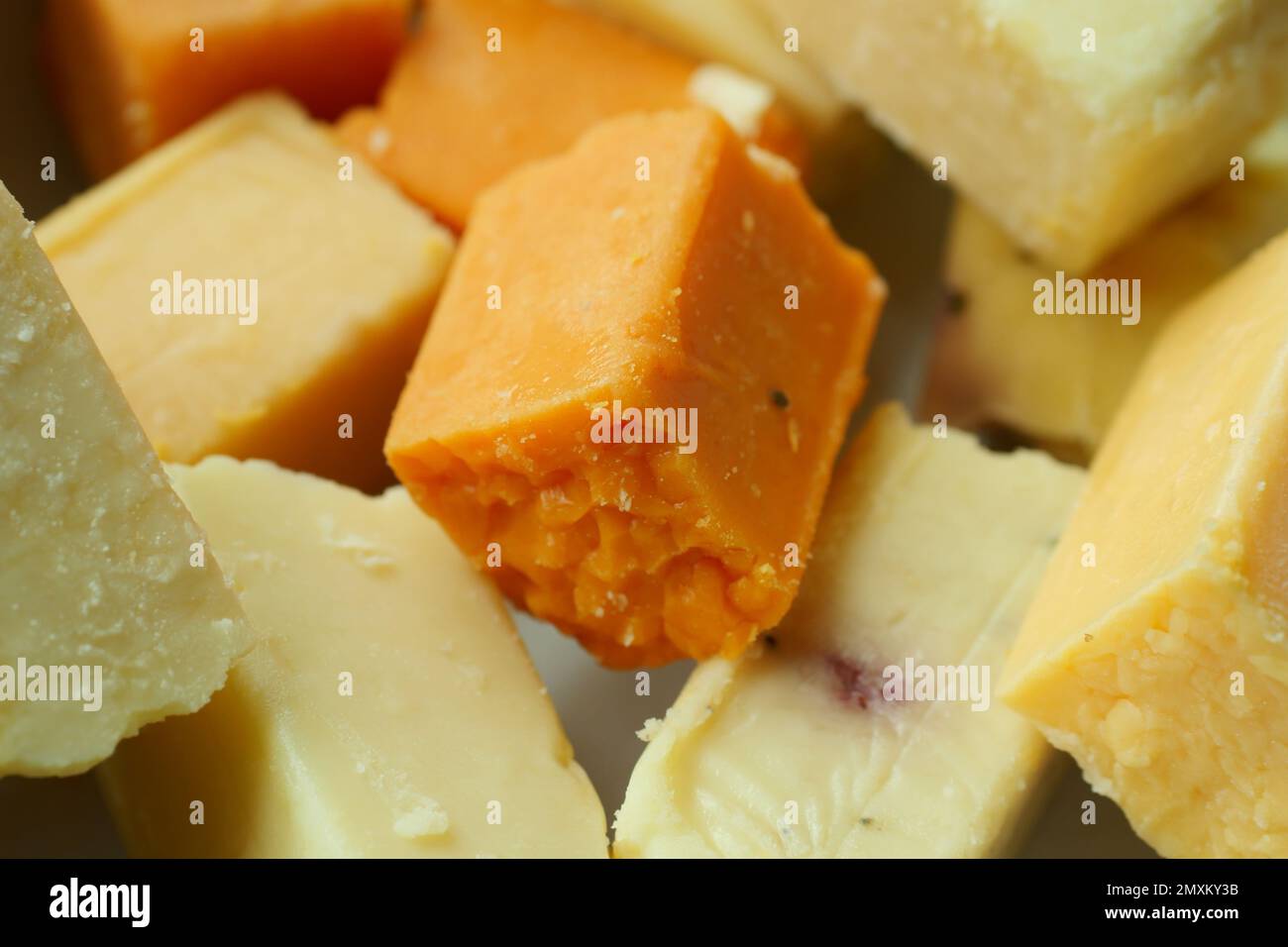 Cheese cubes green, yellow and red color on chopping board Stock Photo ...