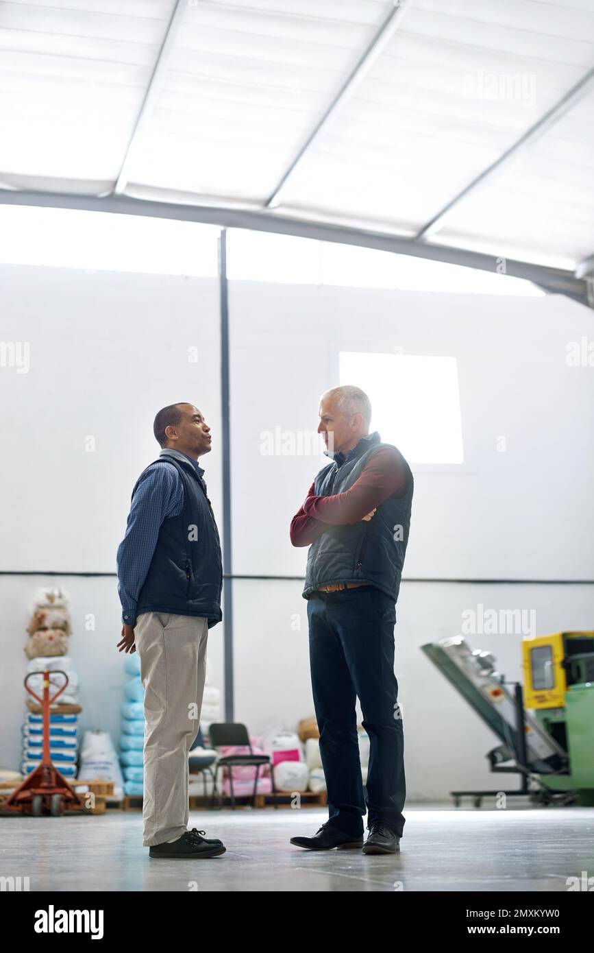 Everyone is accountable. two factory managers doing a warehouse ...