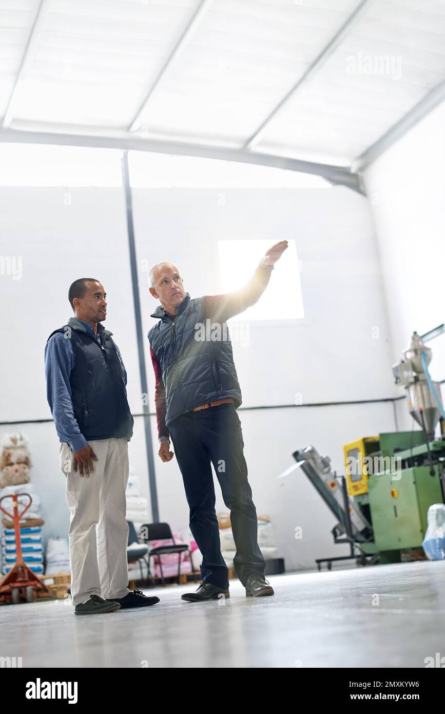 Inspecting the factory equipment. two factory managers doing a ...
