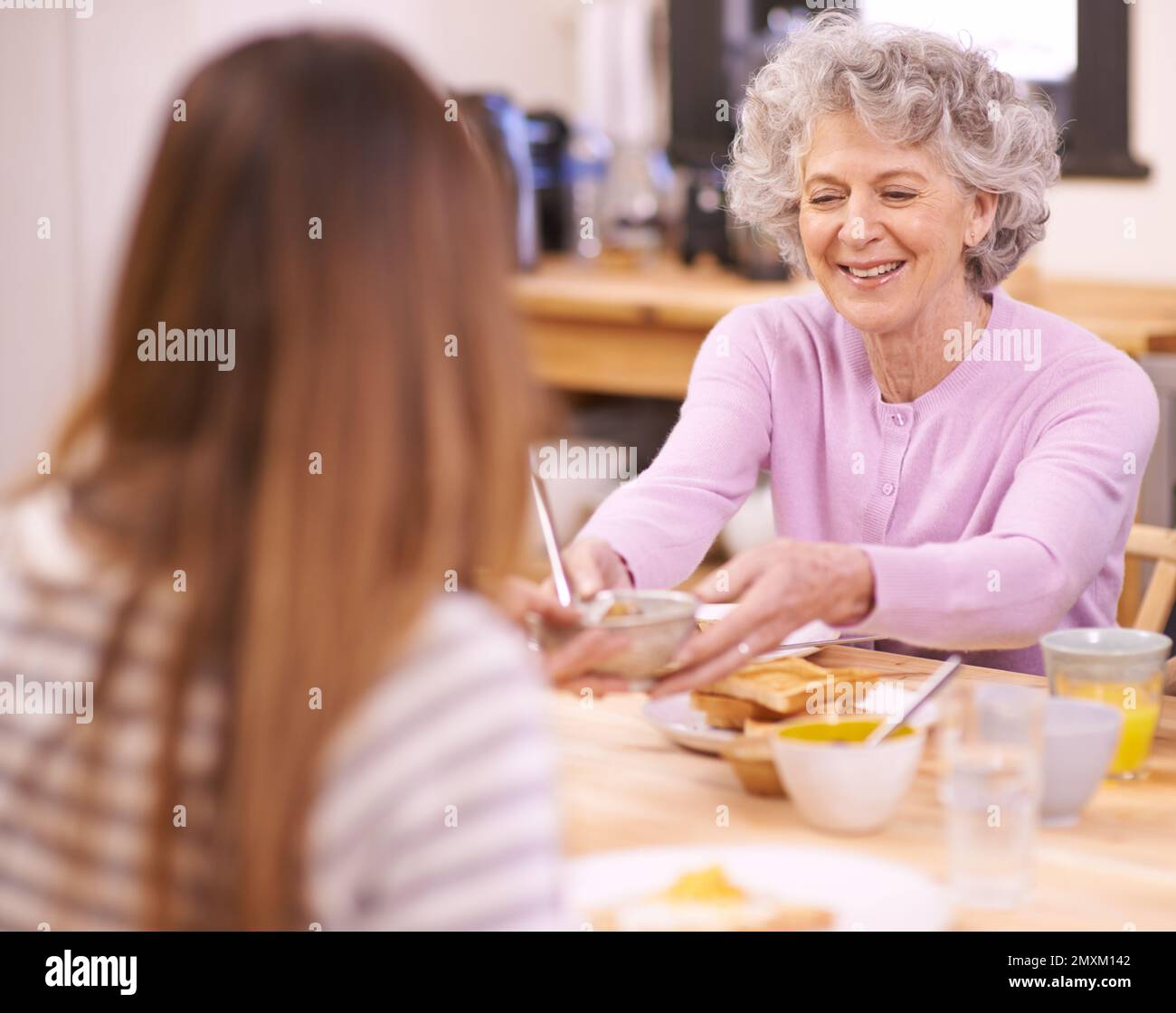 Sharing a meal. a family eating breakfast around the kitchen table ...