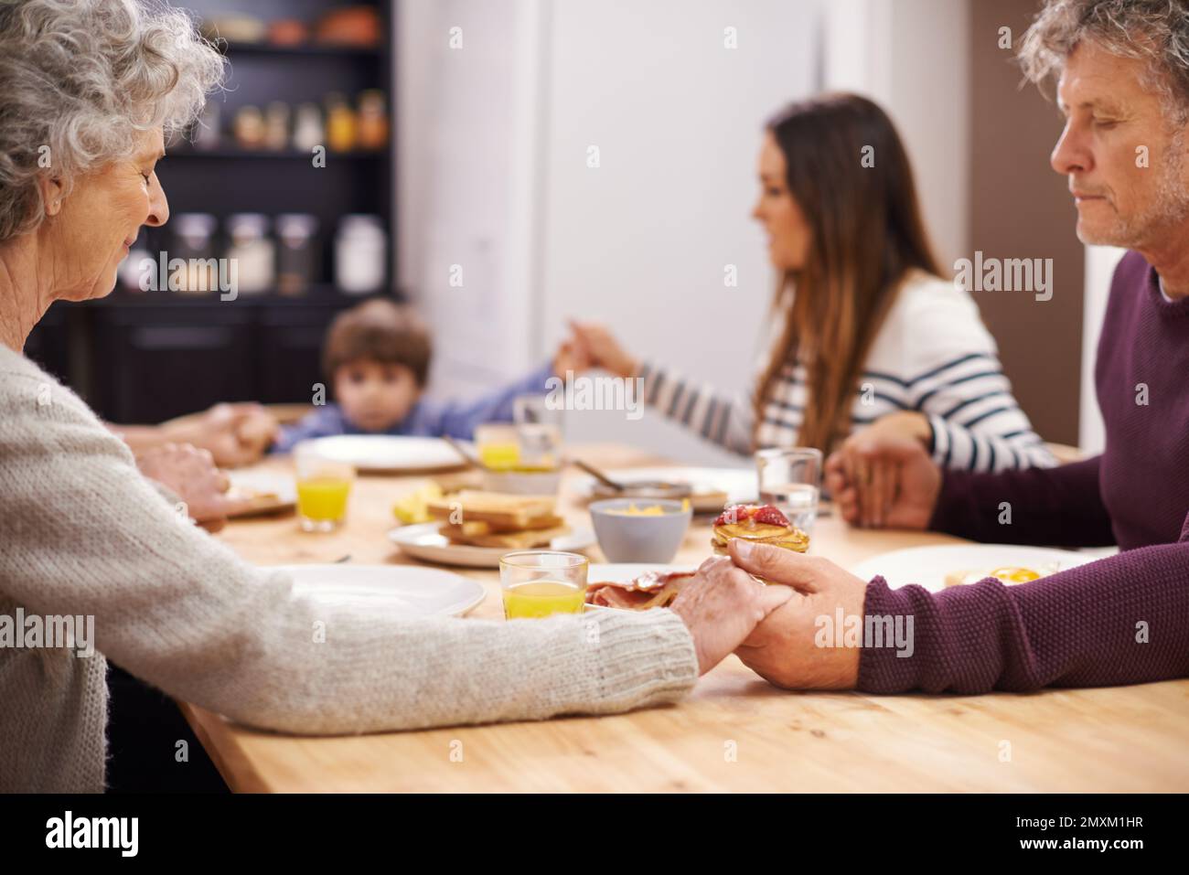 Thankful for delicious food. a family saying grace before eating ...