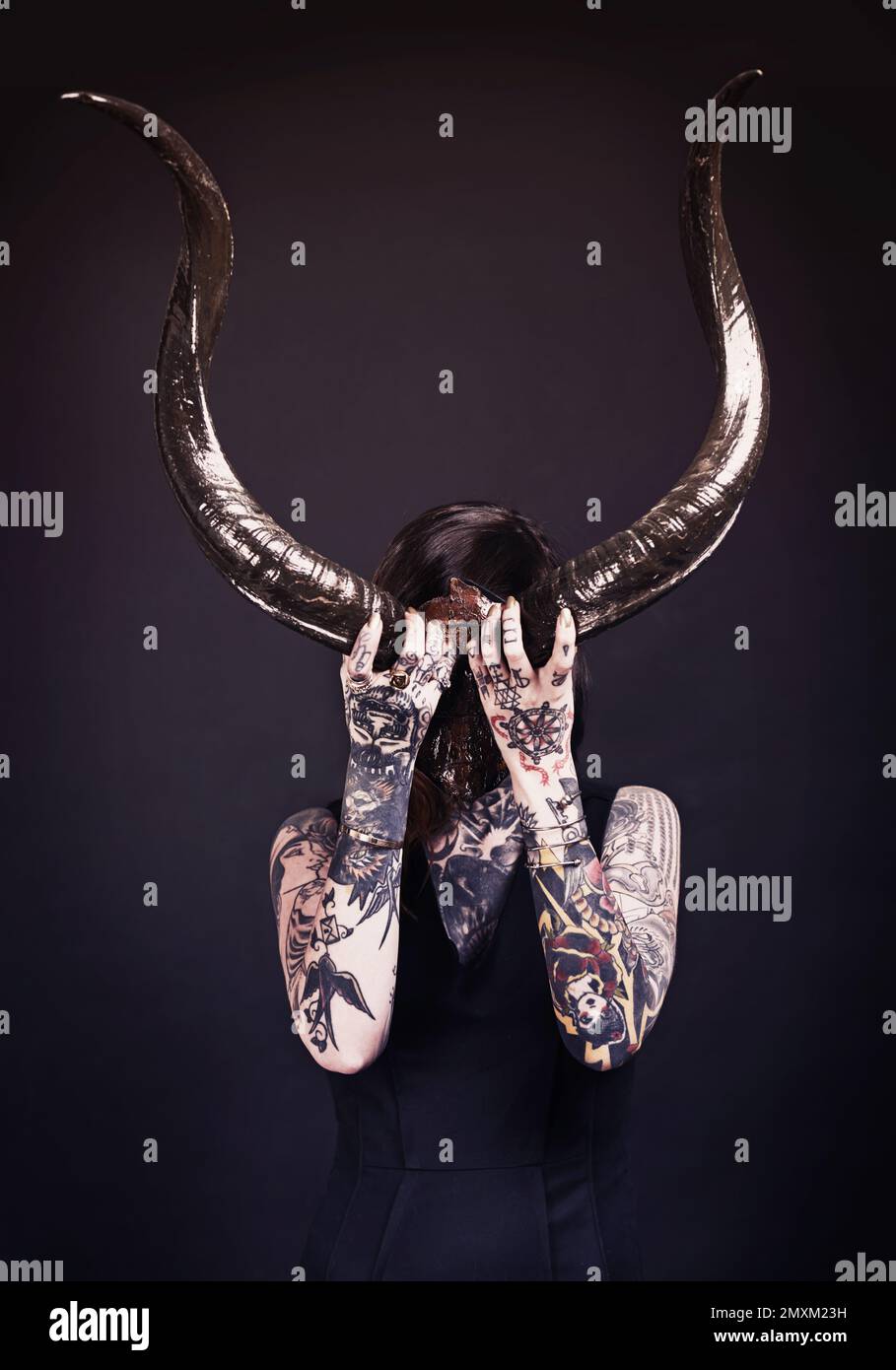 Flirting with the devil. Studio shot of a tattooed young woman Stock ...