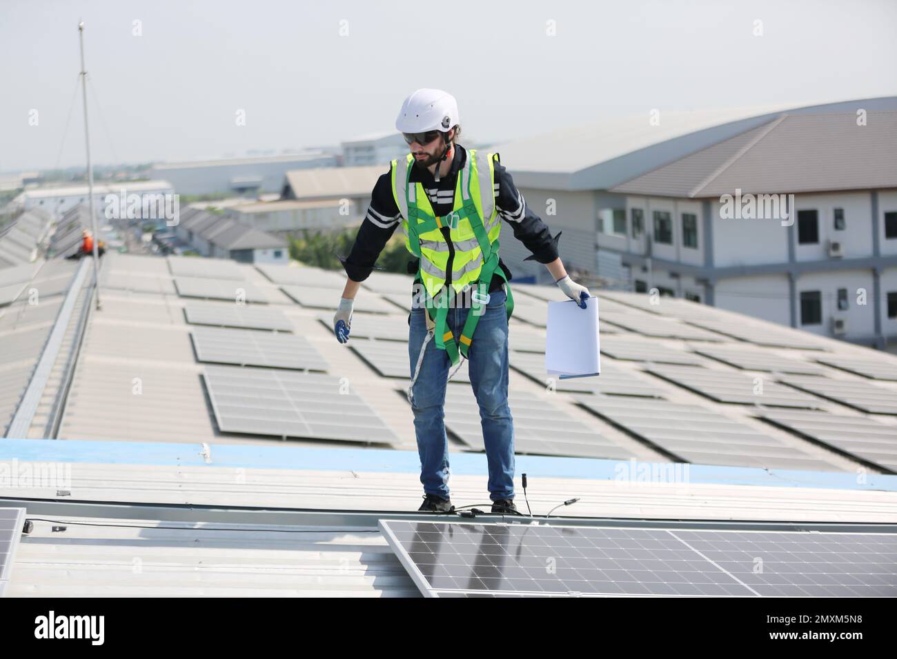 engineers installing solar panels on roof. Male engineers walking along ...