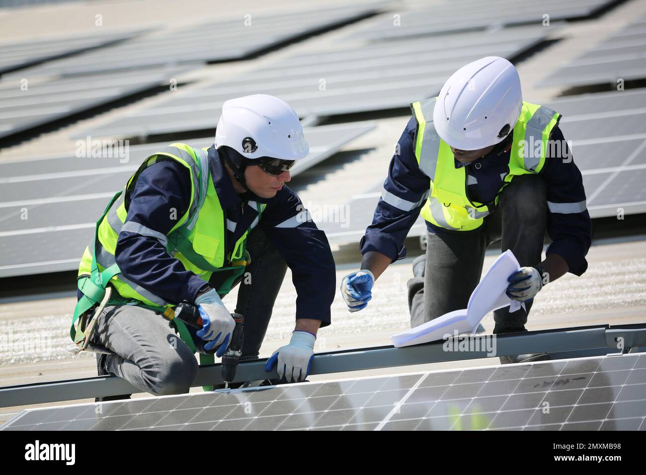 engineers installing solar panels on roof. Male engineers walking along ...