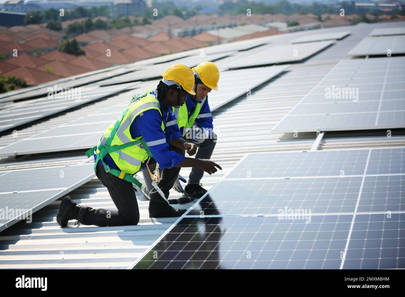 engineers installing solar panels on roof. Male engineers walking along ...