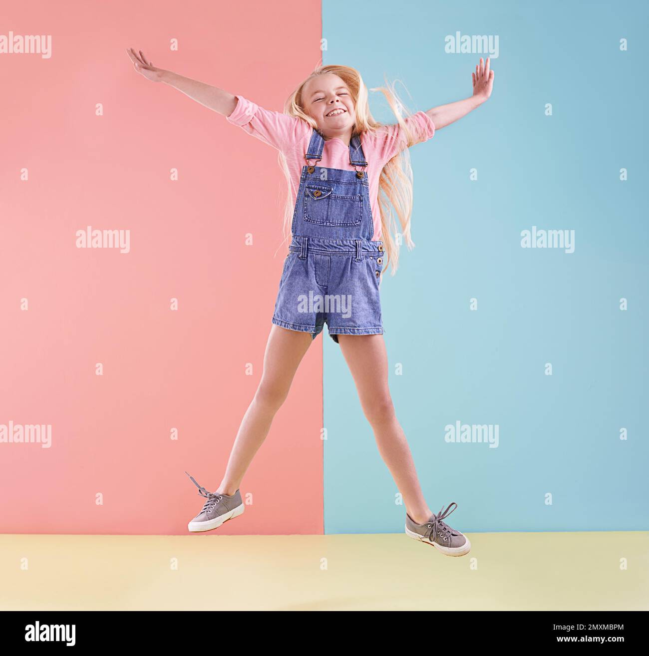 Yay Vacation time is here. A cute little girl jumping against a ...