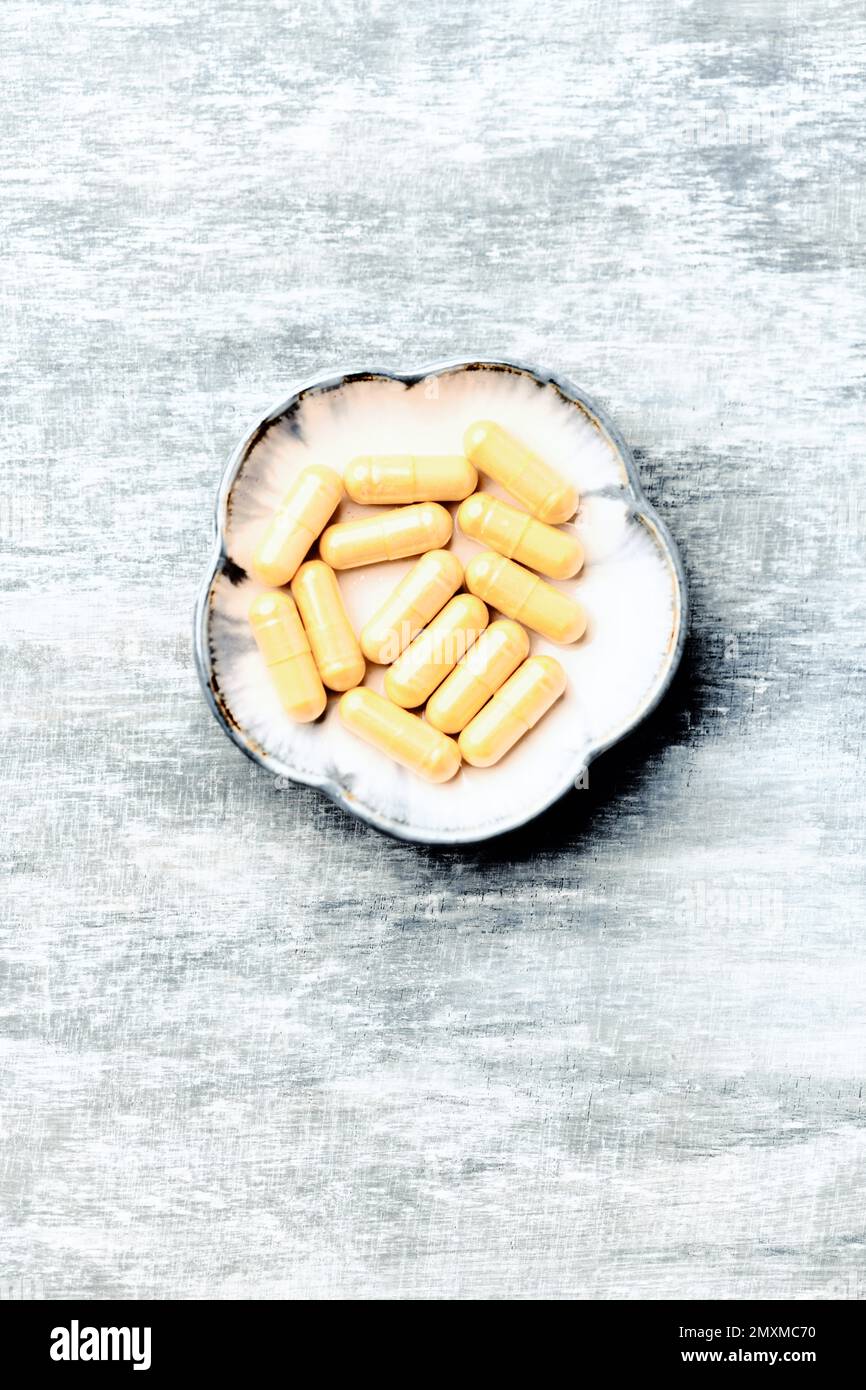 Vitamin B complex capsules. Bright wooden background. Soft focus. Close ...
