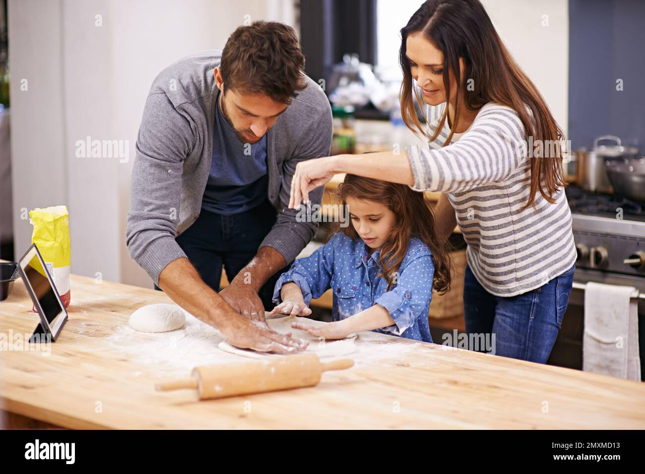 Its a team cooking effort here. a happy family of three baking together ...