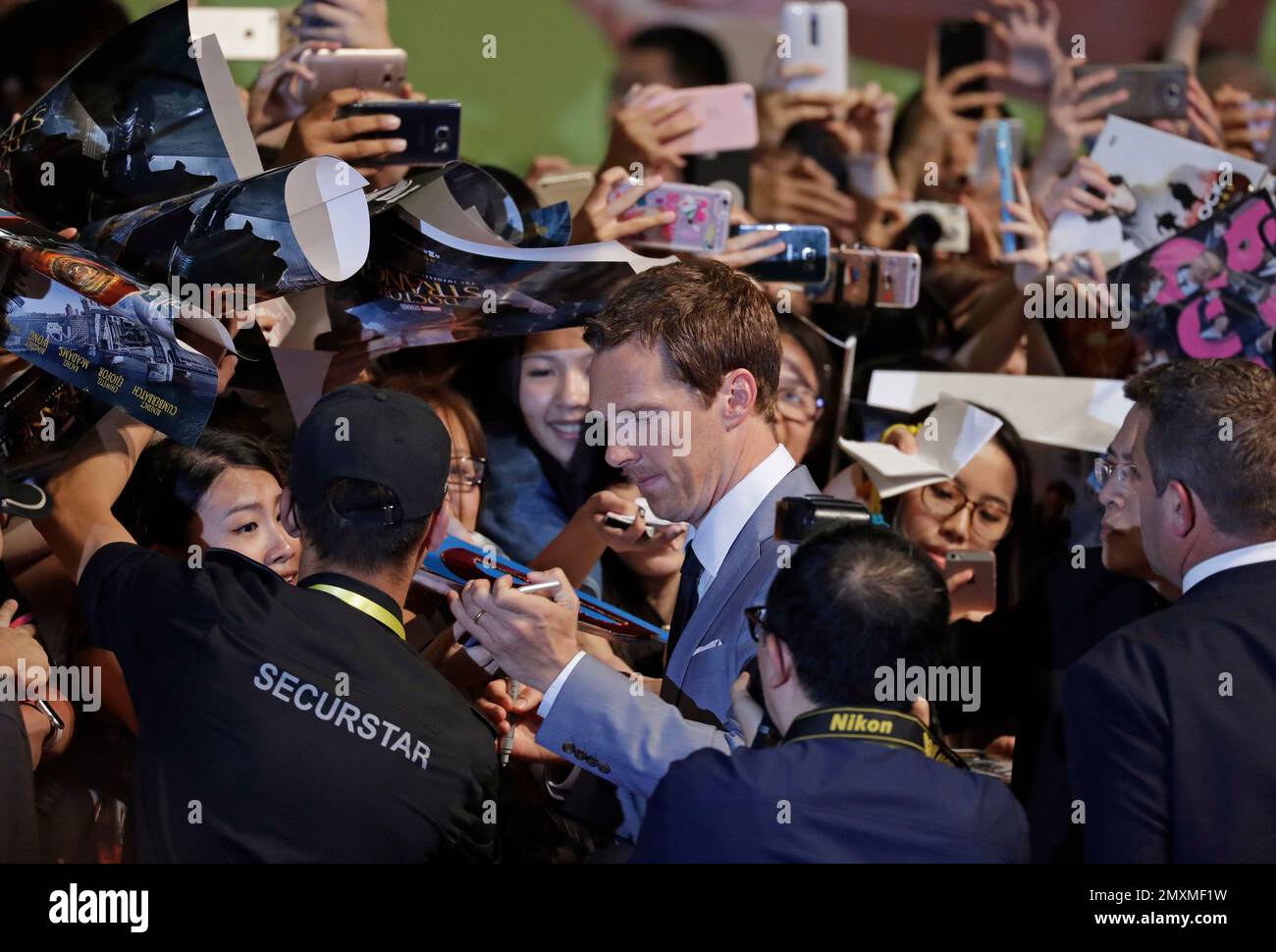 British actor Benedict Cumberbatch, center, signs autographs to fans at ...