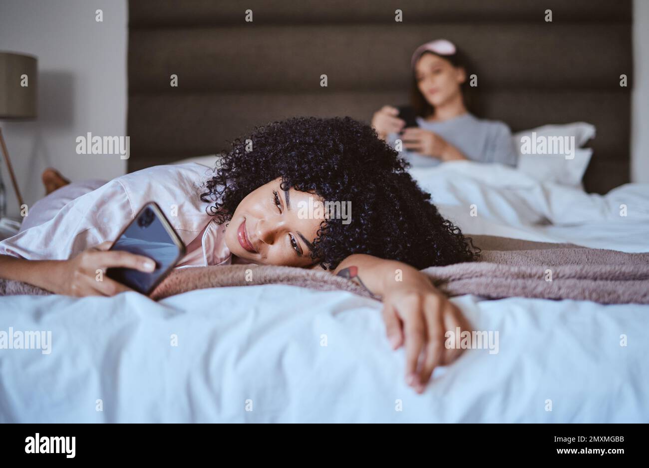 In love, phone and happy with black woman at sleepover for ...
