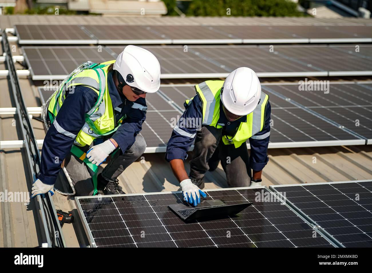 engineers installing solar panels on roof. Male engineers walking along ...