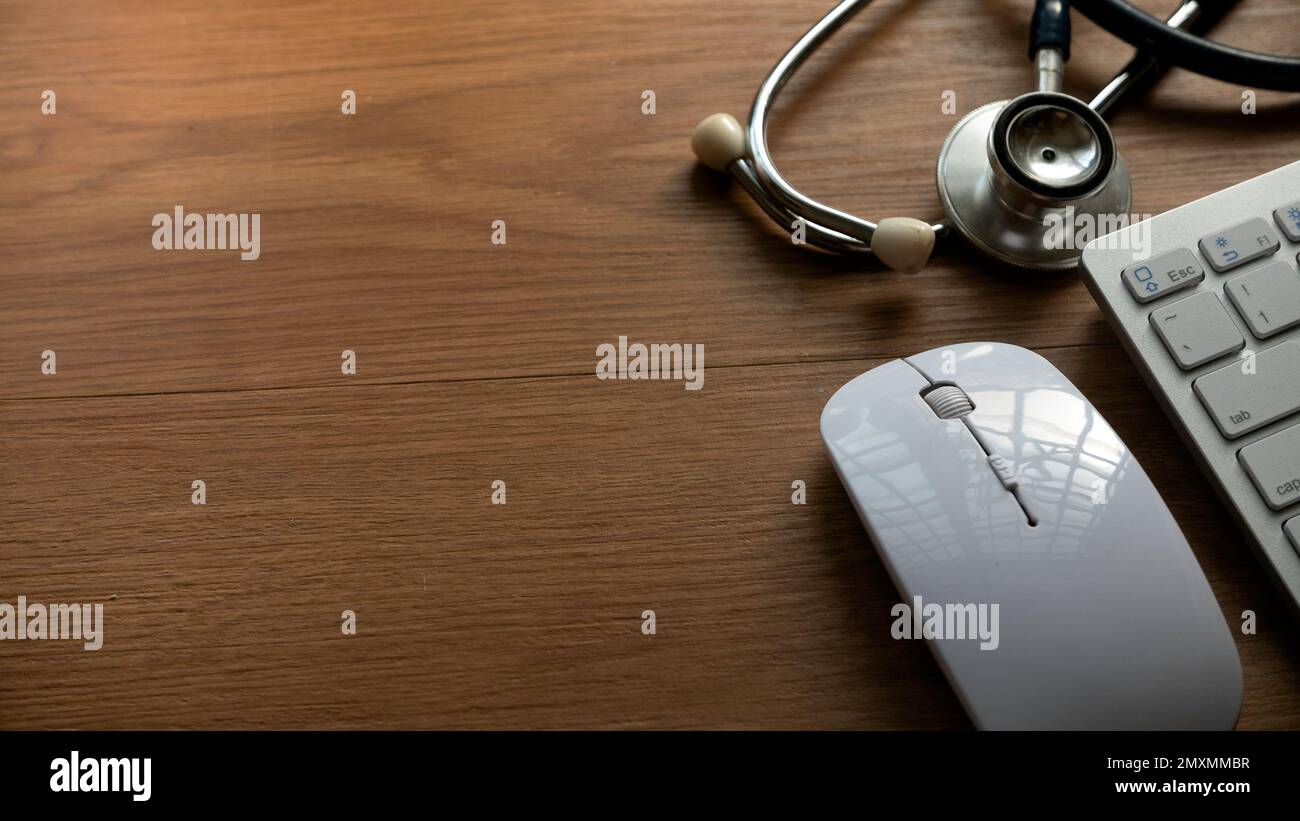 Stethoscope, mouse and computer keyboard on a wooden background with ...