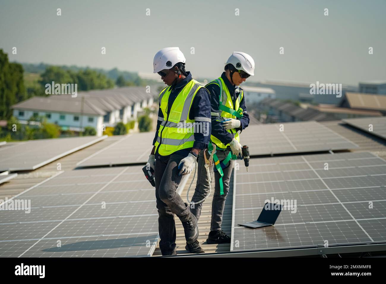 engineers installing solar panels on roof. Male engineers walking along ...