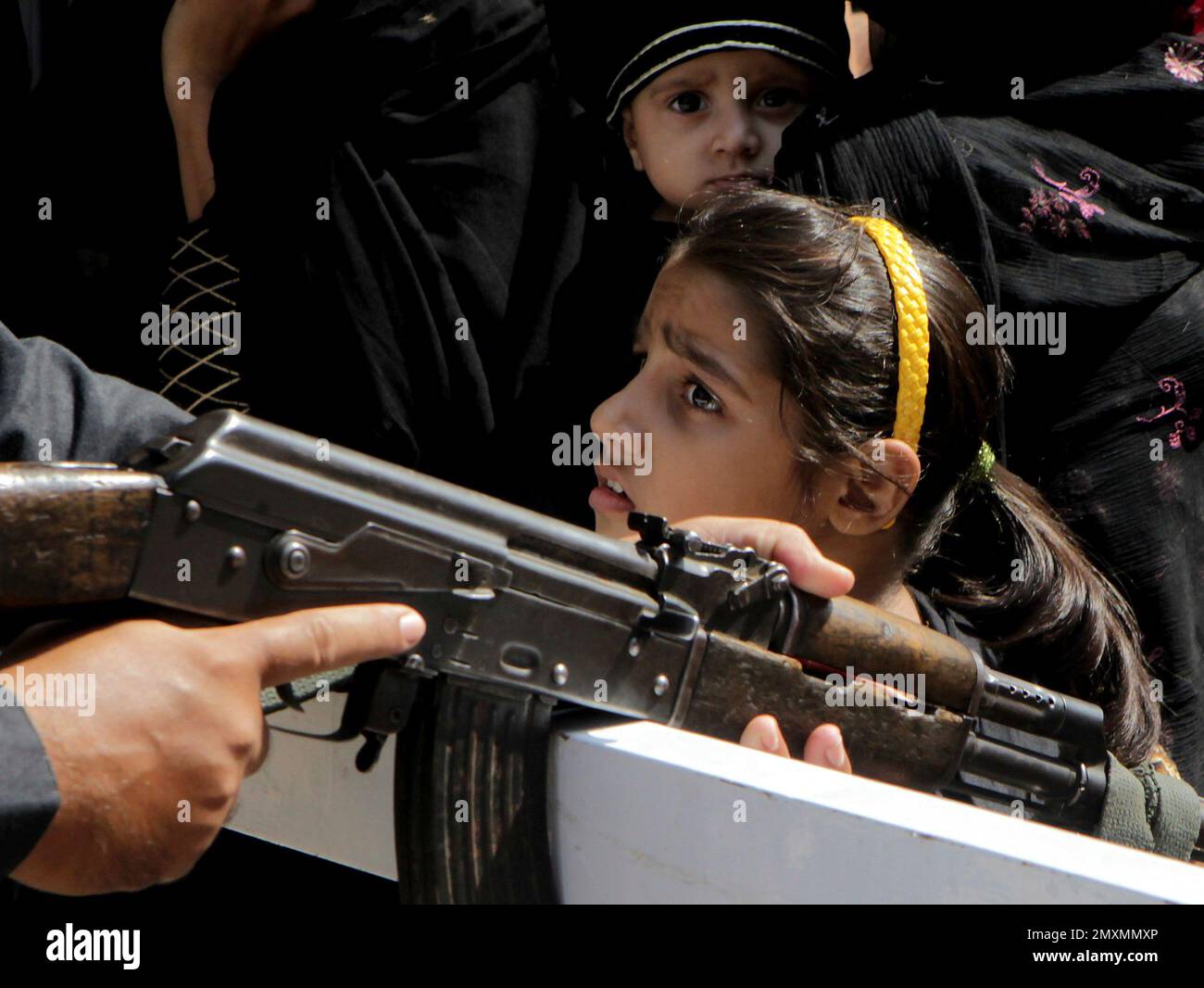 A Pakistani girls looks at a police commando on guard during the ...