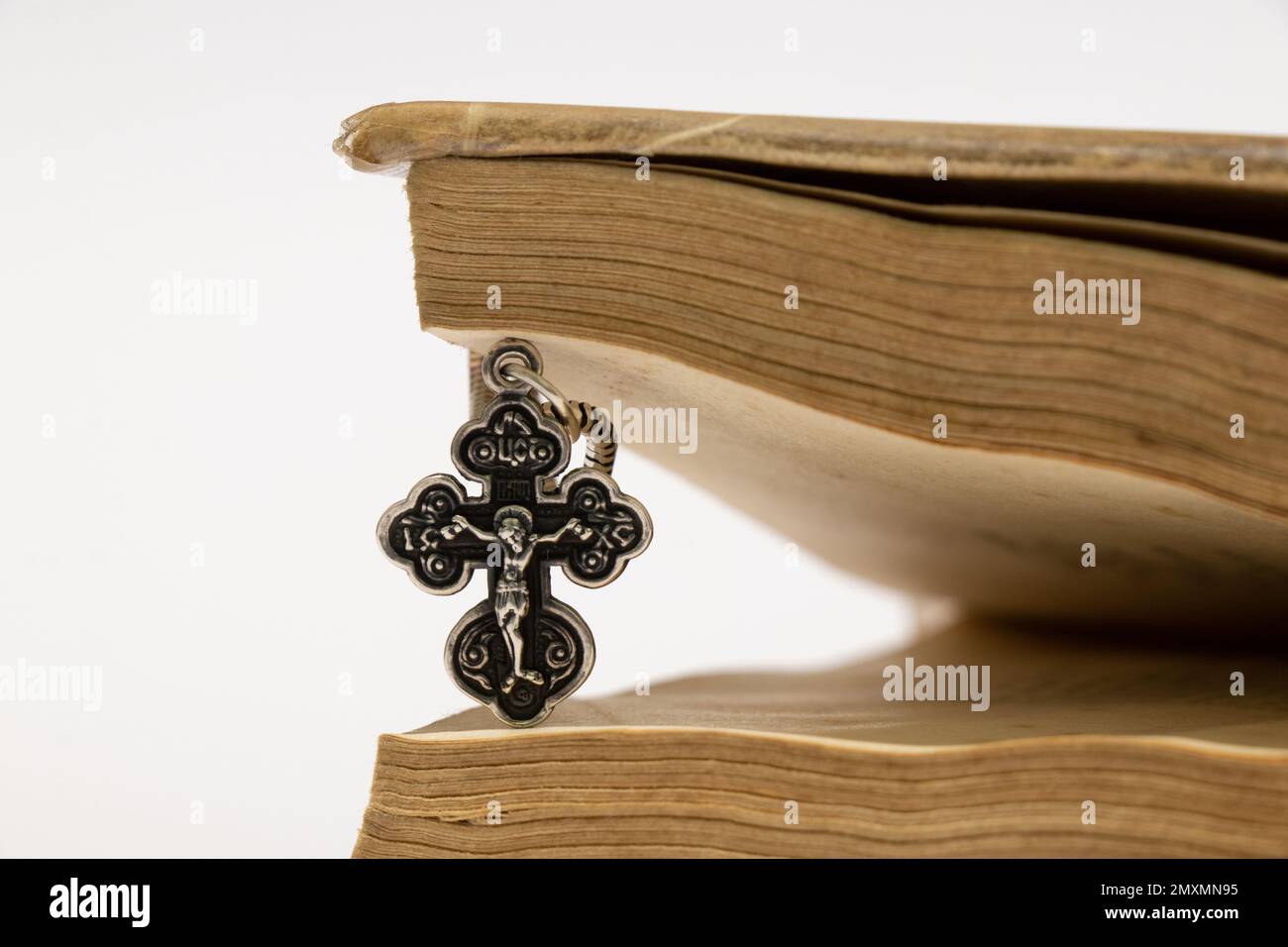 silver christian cross and old book on a white background Stock Photo ...