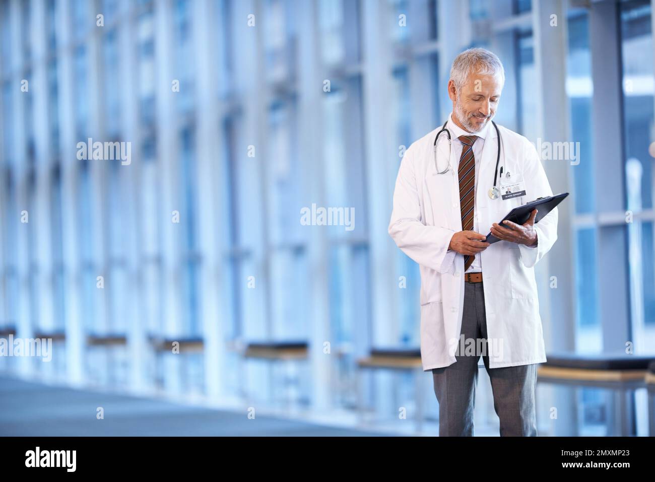Doctor holding file in hospital corridor hi-res stock photography and ...
