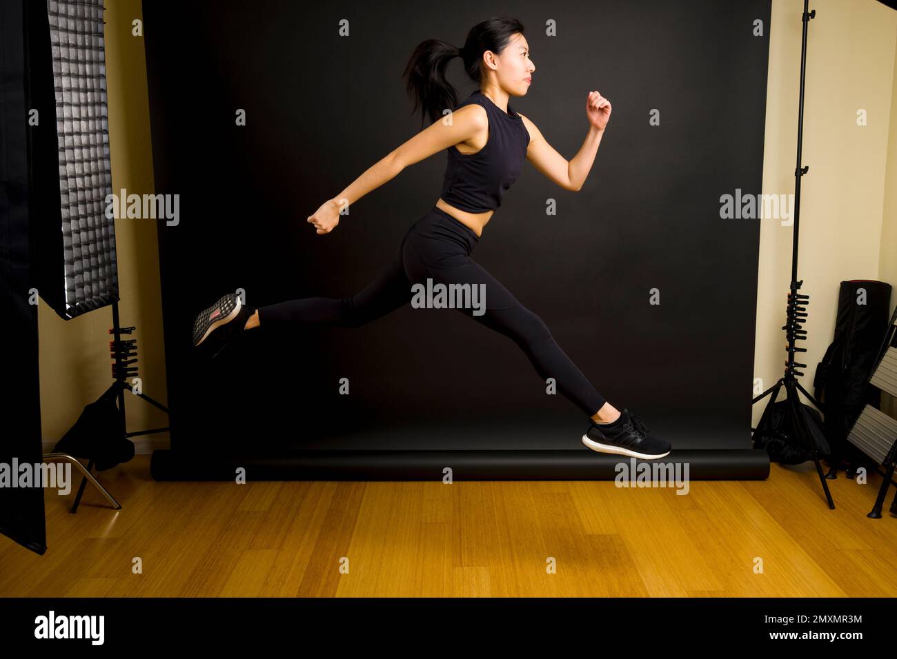 Beautiful Young Asian Runner Woman Taking a Big Stride in the Studio Stock Photo - Alamy