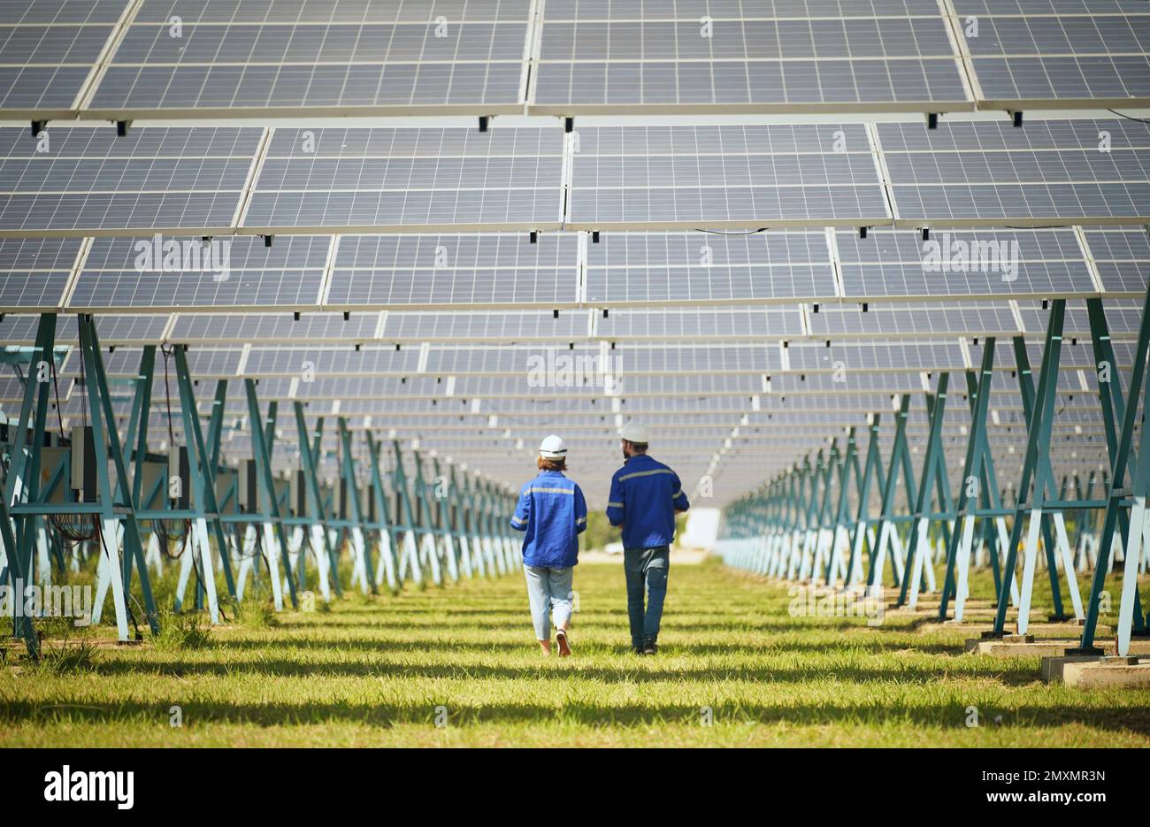 engineers installing solar panels on roof. Male engineers walking along ...