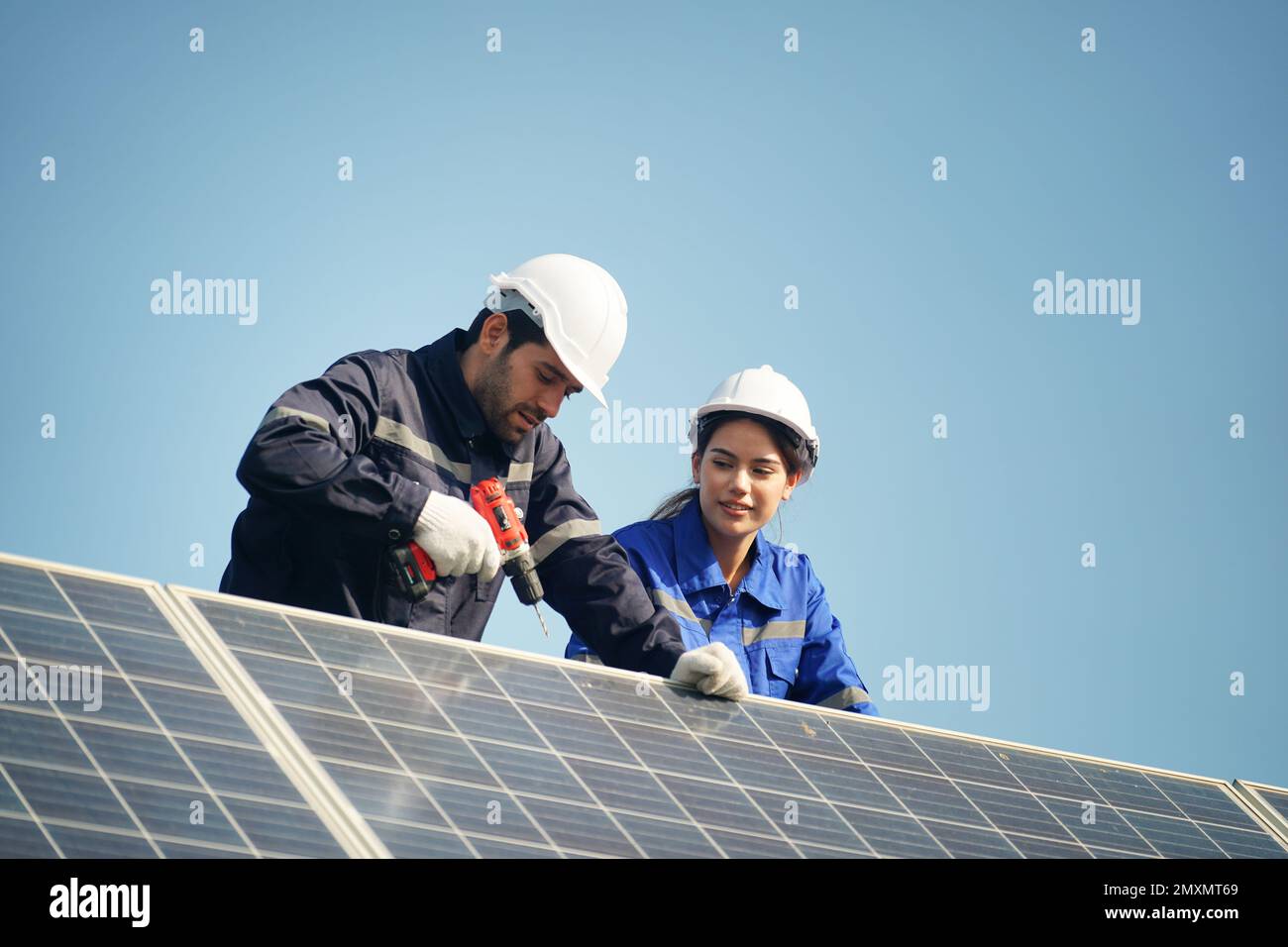 engineers installing solar panels on roof. Male engineers walking along ...