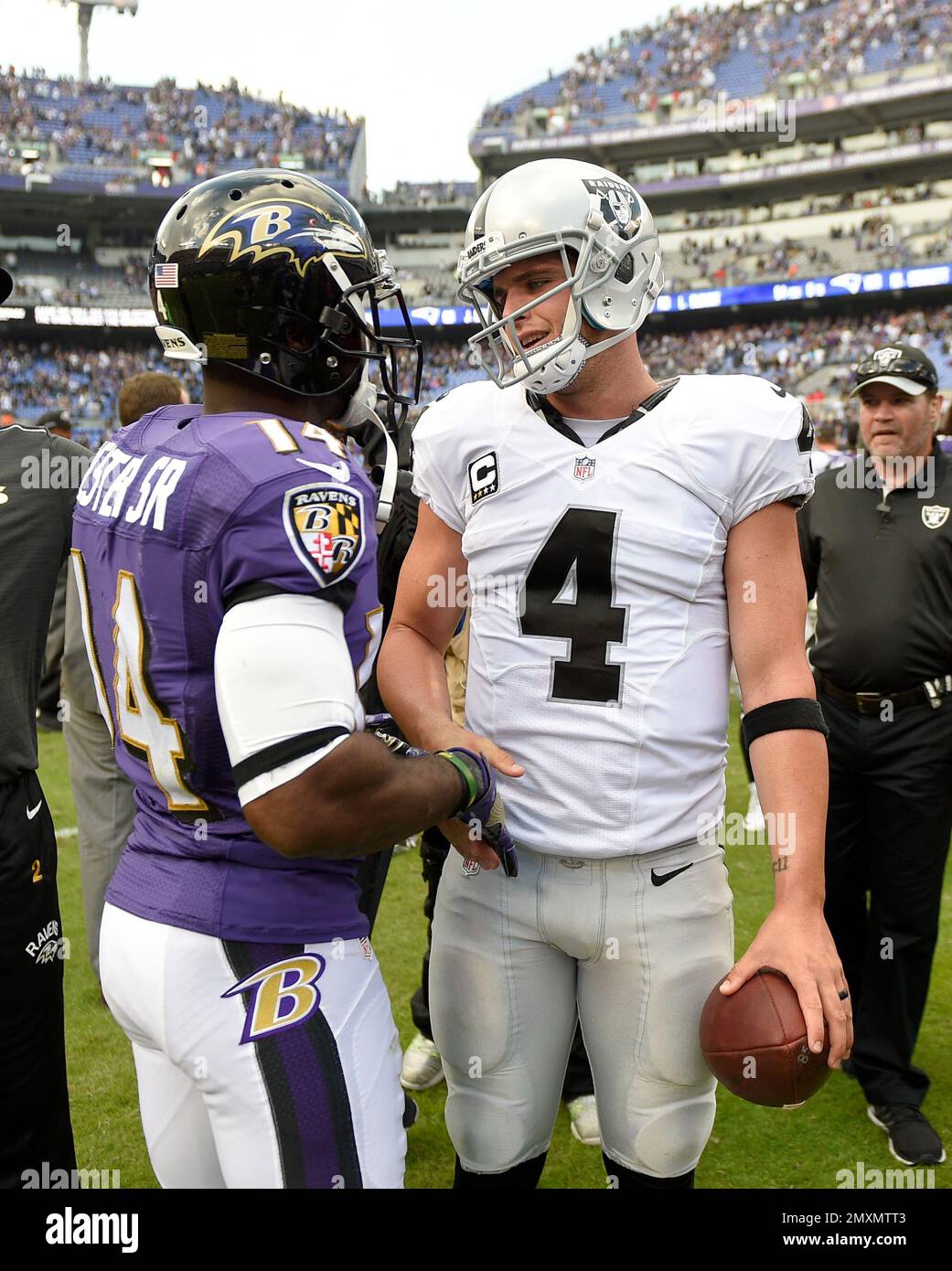 Oakland Raiders quarterback Derek Carr (4) talks with Baltimore Ravens ...