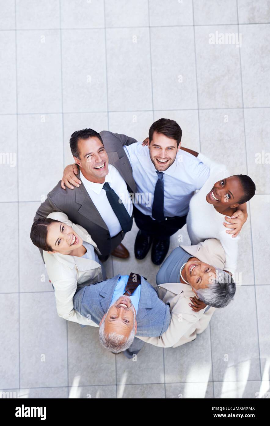 We have each others backs. a group of coworkers standing arm in arm in ...