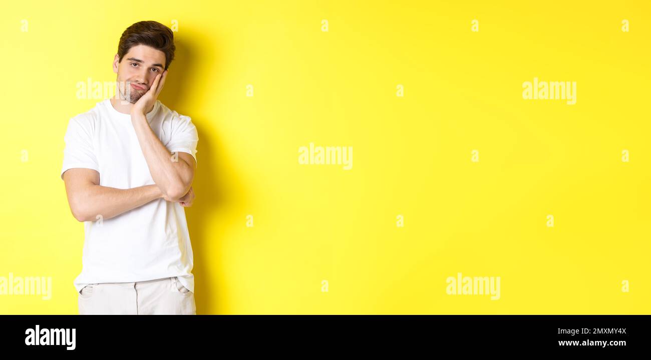 Bored and unamused man looking with indifference, standing in white ...