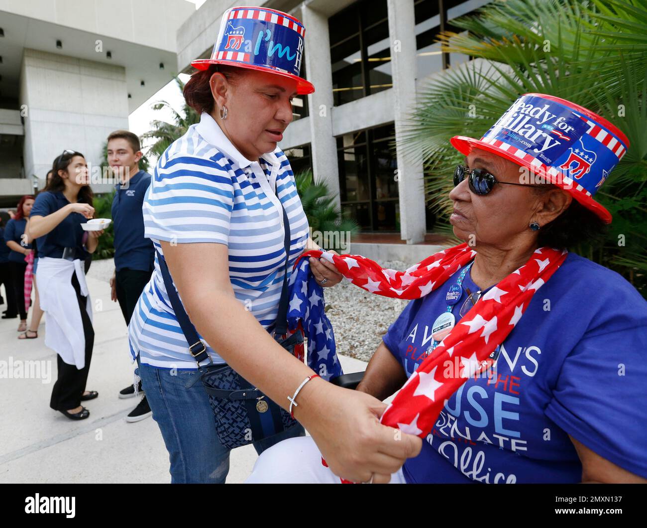 Reina Menoza, center, puts a patriotic scarf on her mother Maria as ...