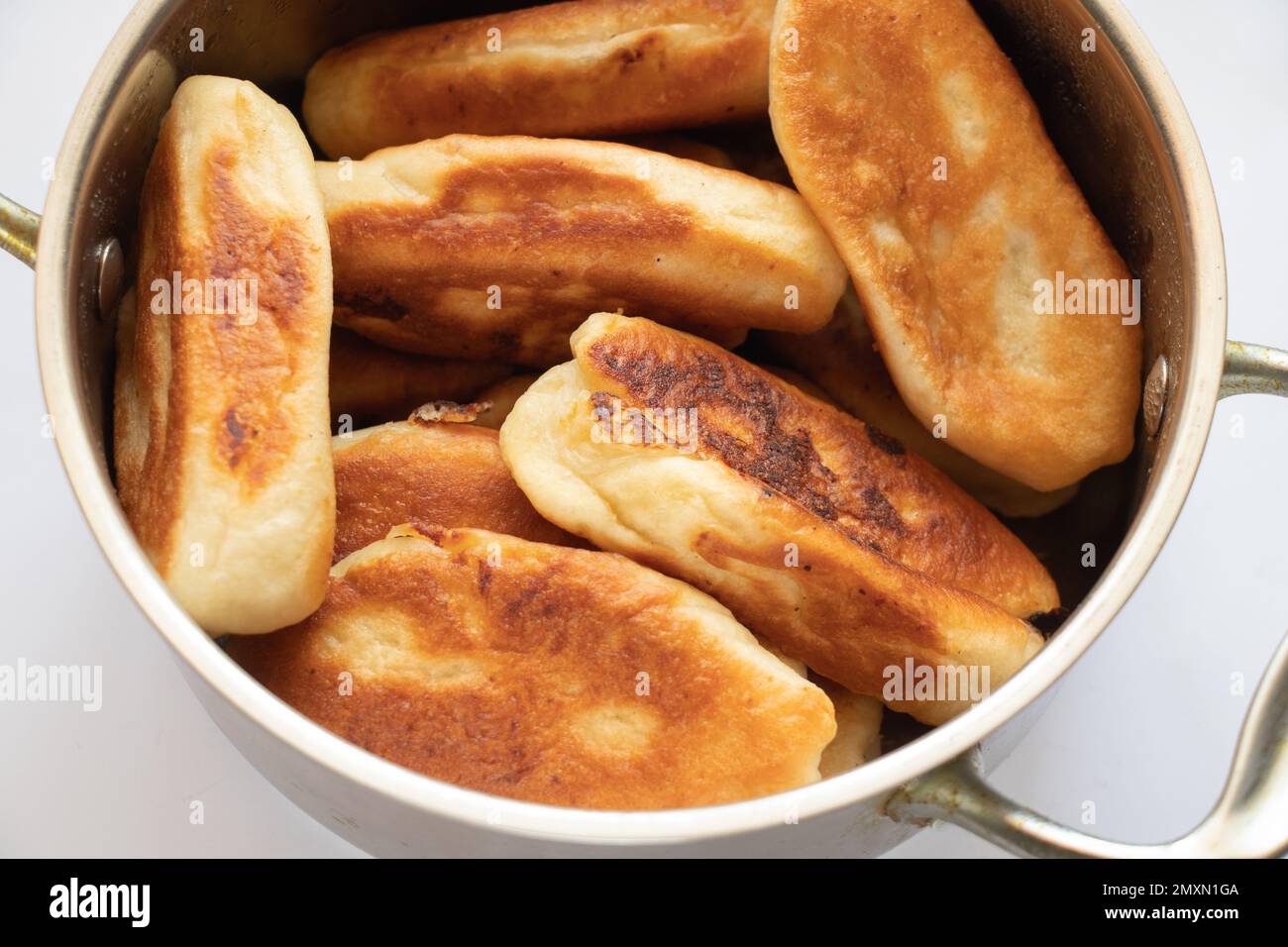 fried pies in a pan on a white background Stock Photo - Alamy
