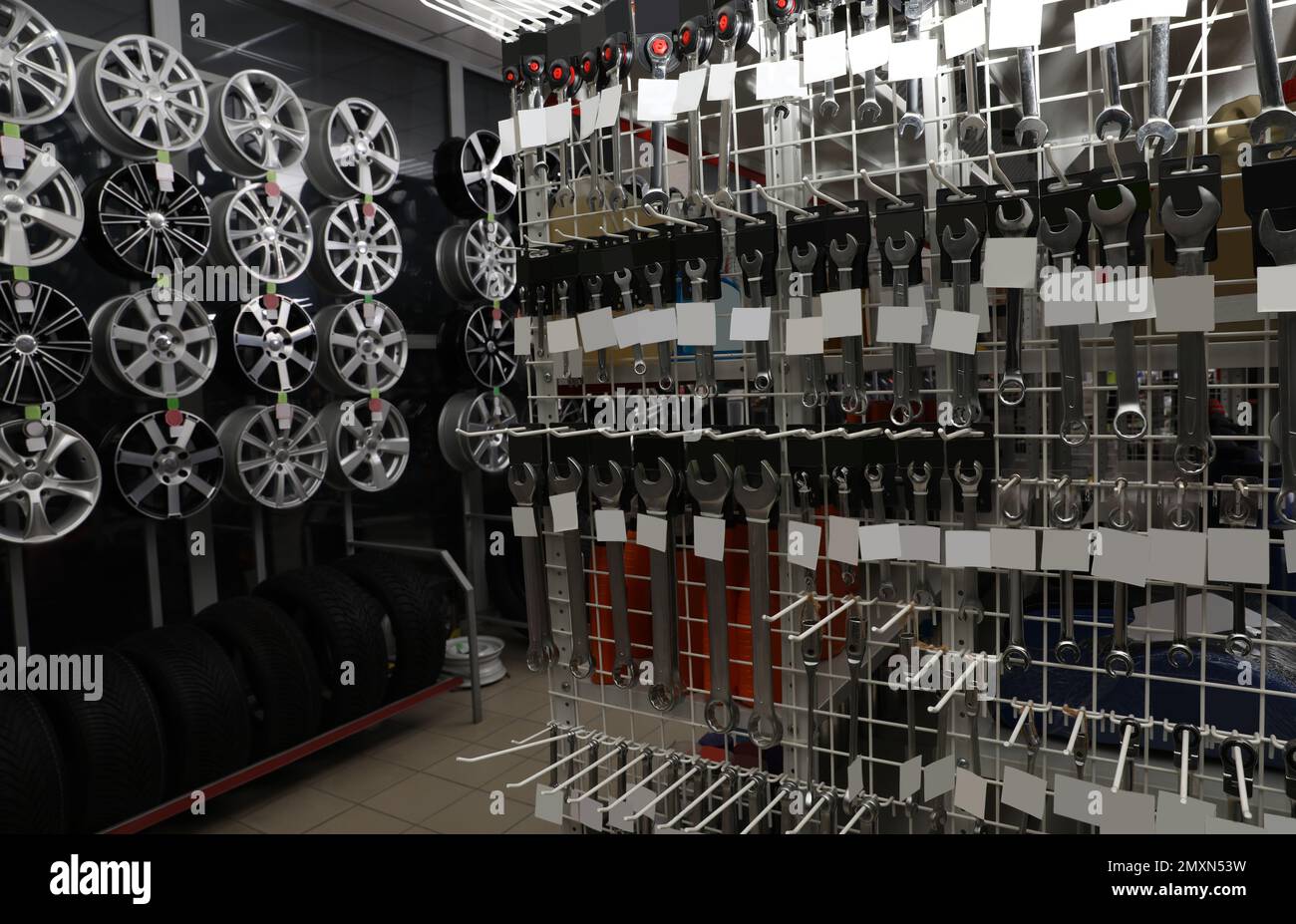 Set of tools, alloy wheels and tires in auto store Stock Photo - Alamy