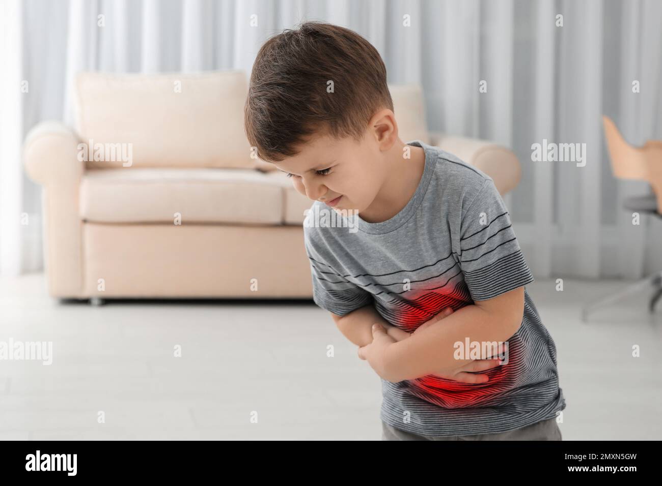 Little boy suffering from stomach pain in living room Stock Photo - Alamy