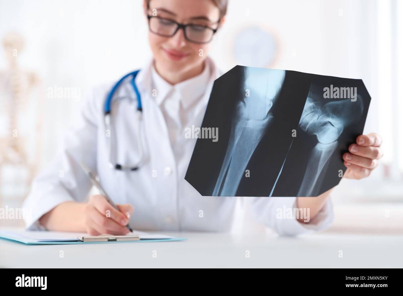 Orthopedist examining radiography at desk in office, focus on X-ray ...
