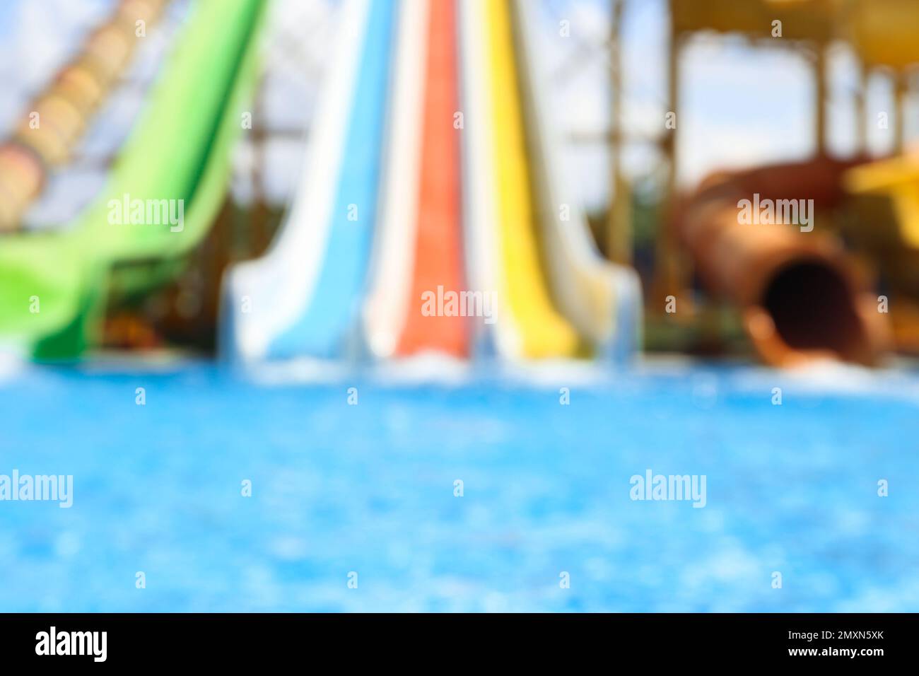 Different colorful slides in water park, blurred view Stock Photo - Alamy