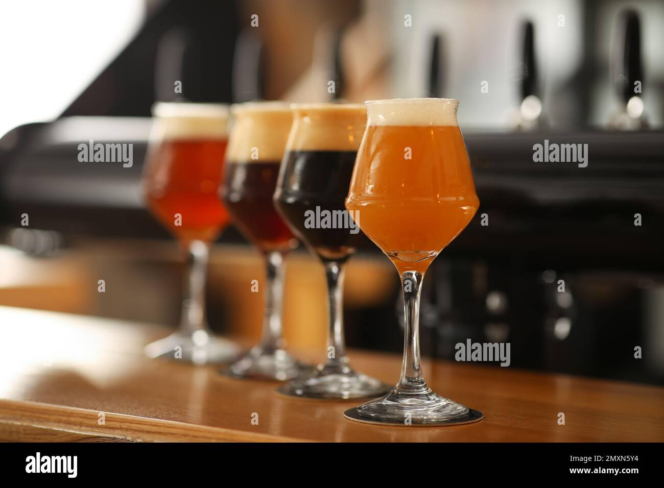 Different beers in glasses on bar counter Stock Photo - Alamy