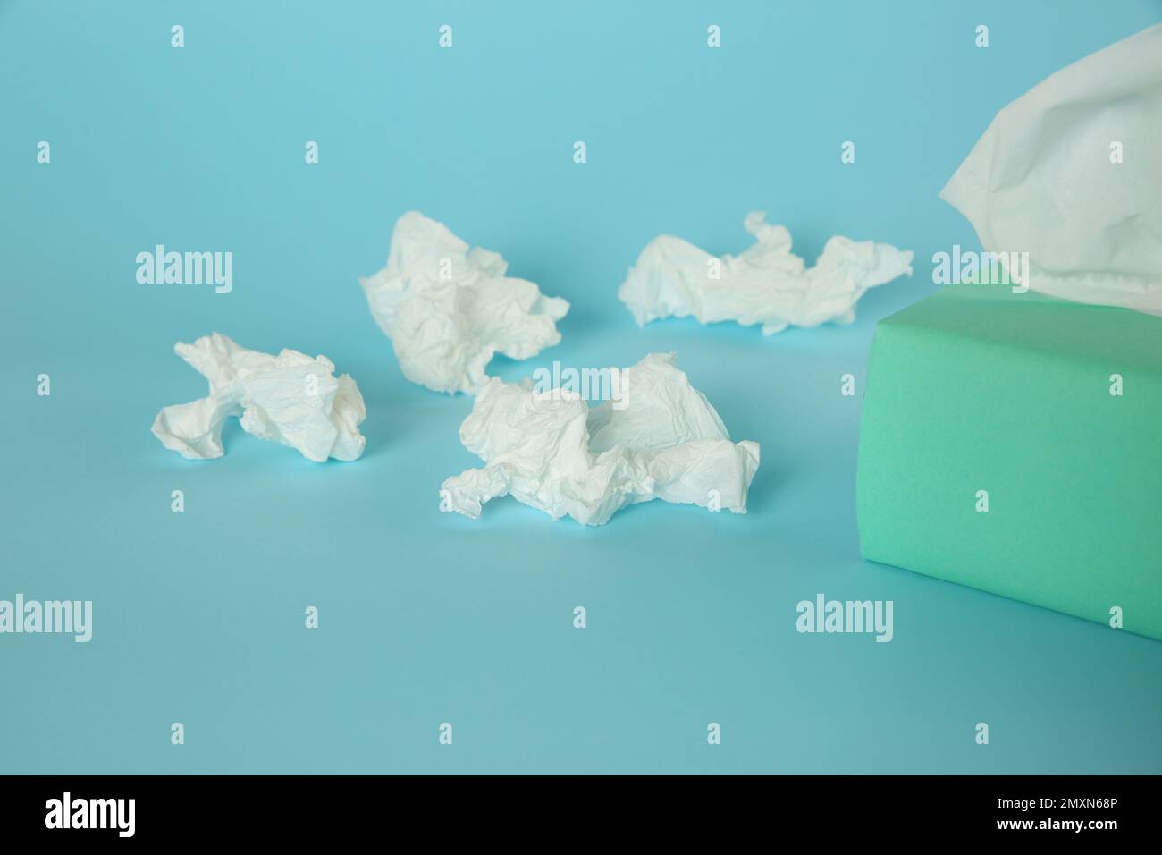 Used paper tissues and box on light blue background Stock Photo - Alamy