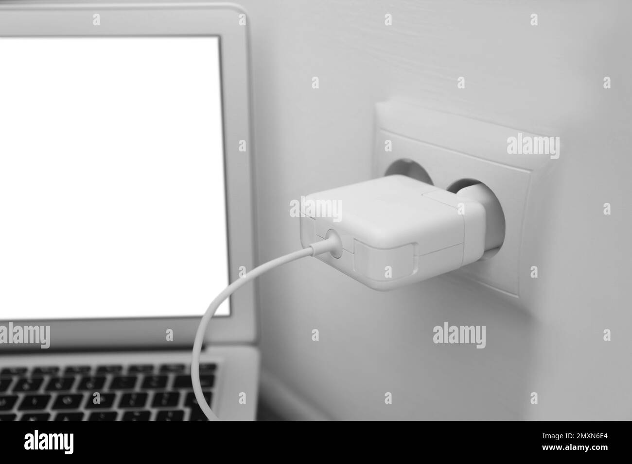 Modern laptop charging from electric socket indoors, closeup Stock ...