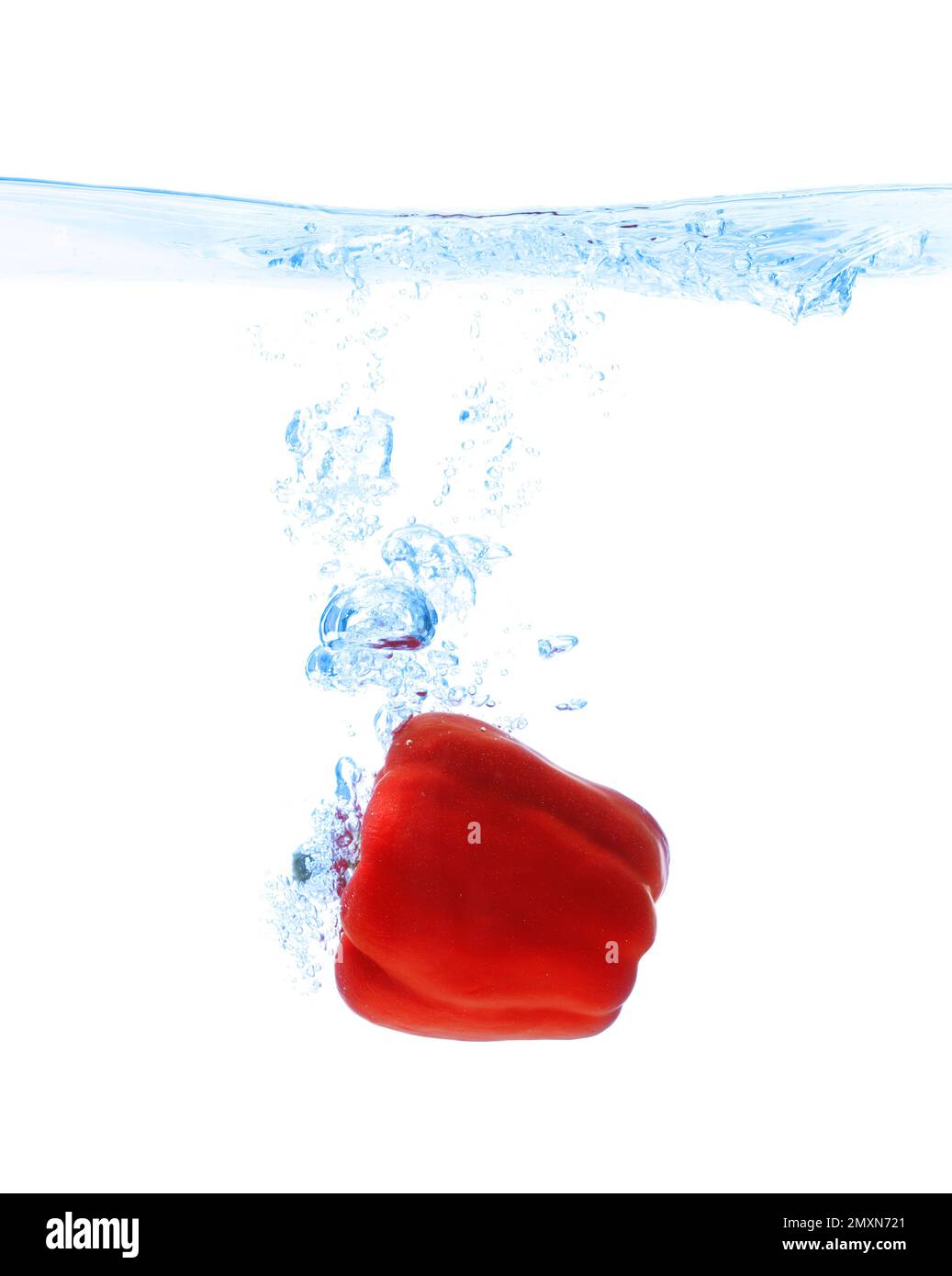 Red bell pepper falling down into clear water against white background ...