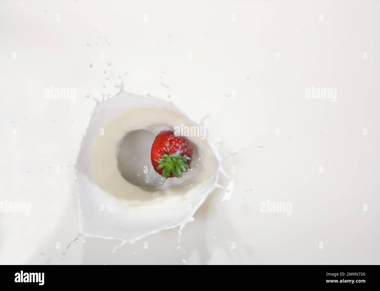 Strawberry falling in milk with splash, top view Stock Photo - Alamy