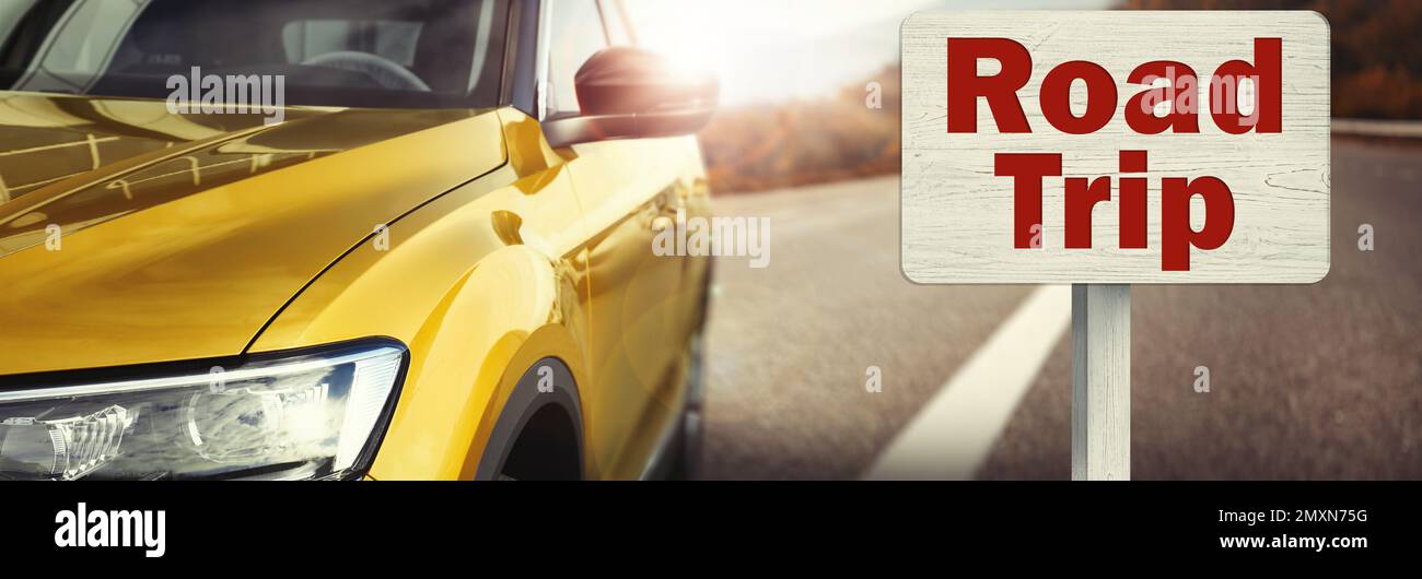 Wooden plaque with inscription road trip. Car driving on highway ...