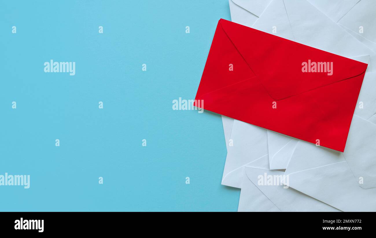 A stack of white envelopes with a red envelope on top. Blue background ...