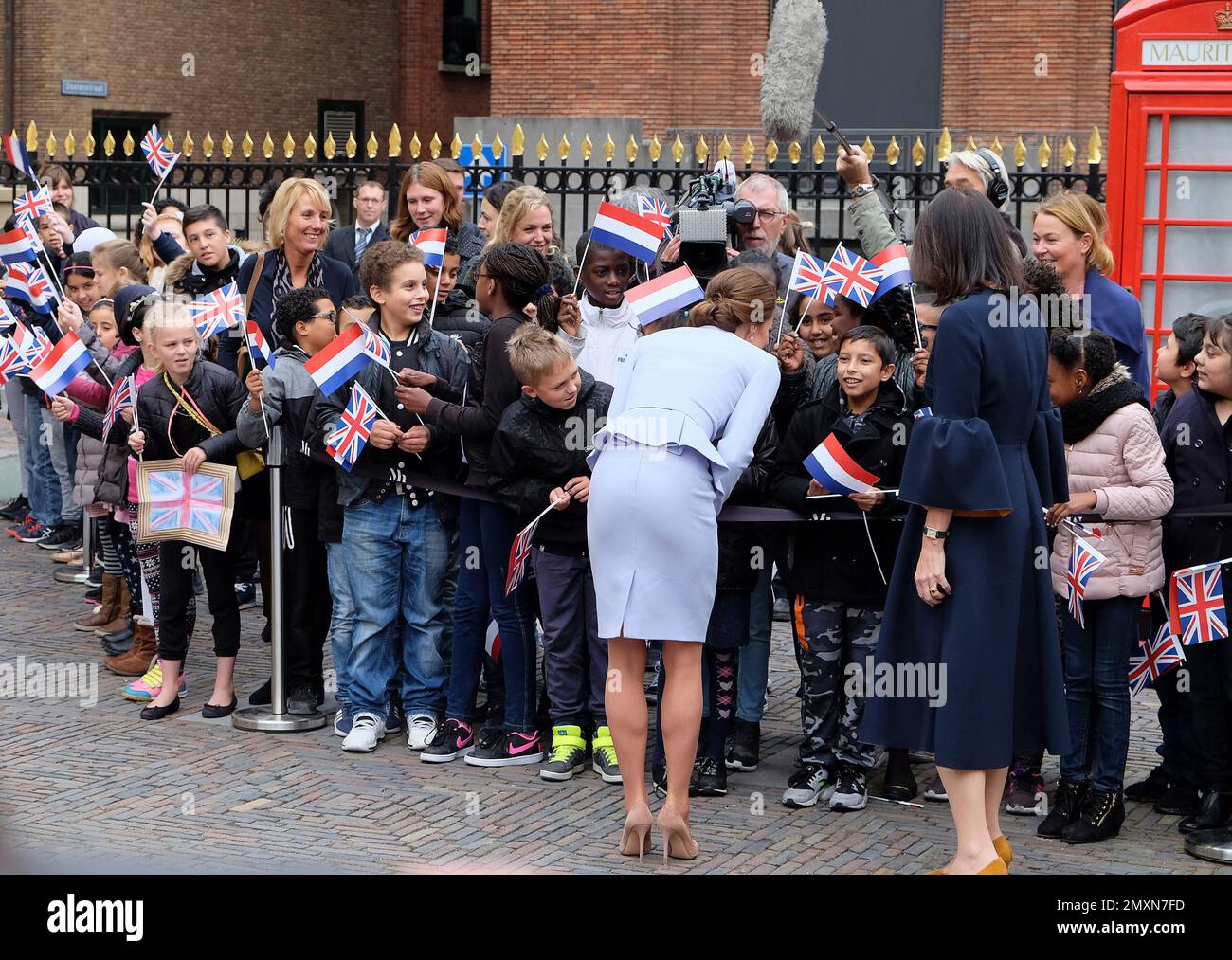 Britain's Kate, the Duchess of Cambridge, center in light blue, talks ...