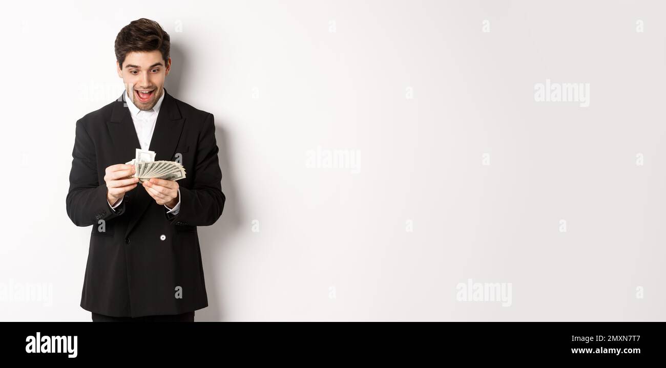 Image of excited handsome businessman, counting money and smiling ...